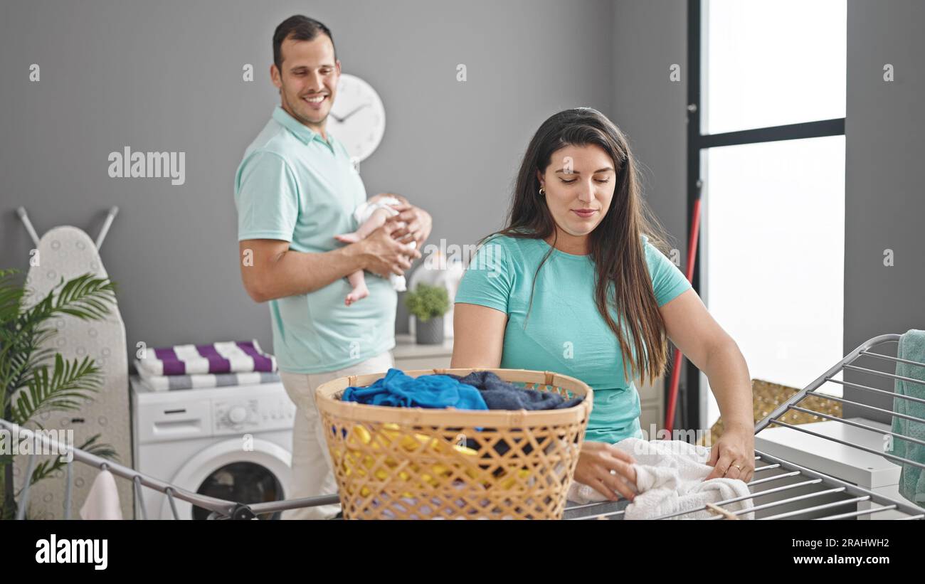 Family of three hanging clothes on clothesline at laundry room Stock ...