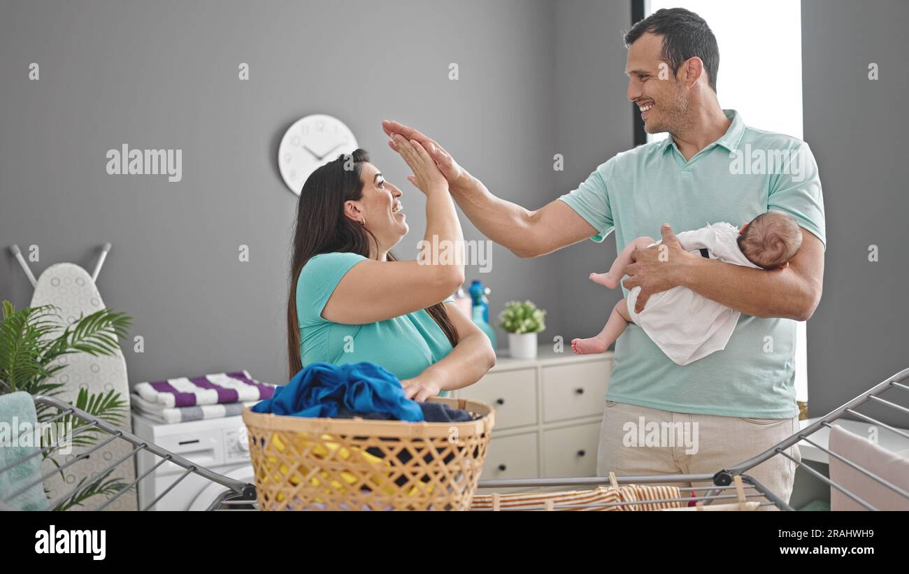 Family of three hanging clothes on clothesline at laundry room Stock ...