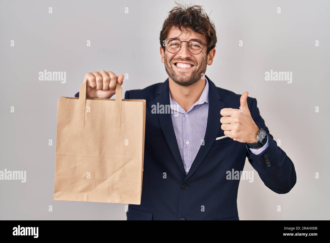 Hispanic business man holding delivery bag smiling happy and positive ...