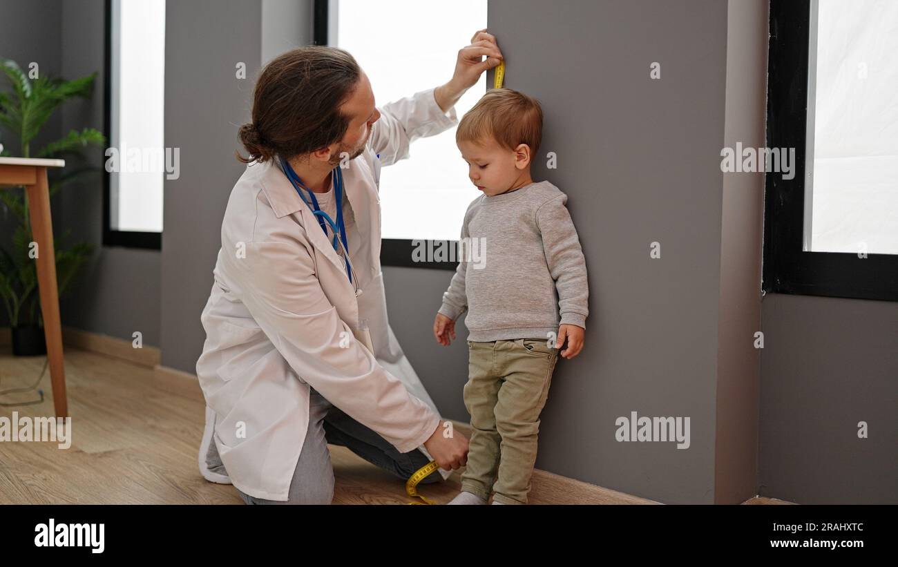 Father and son doctor measuring kid at clinic Stock Photo - Alamy