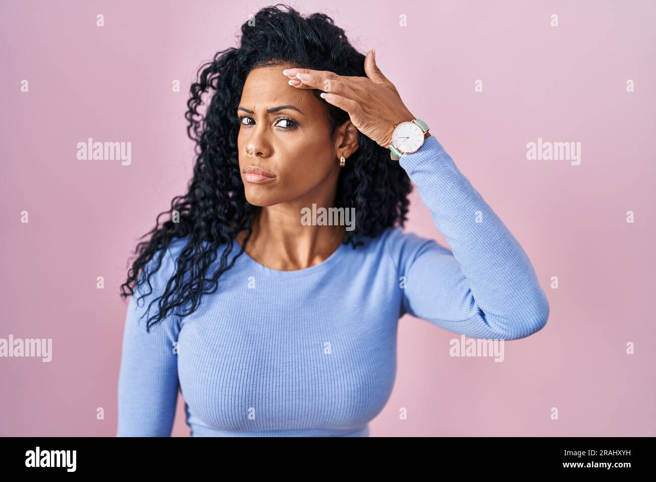 Middle age hispanic woman standing over pink background pointing ...