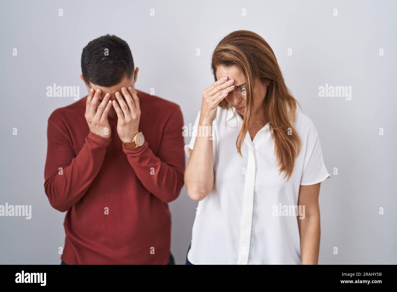 Mother and son standing together over isolated background with sad ...