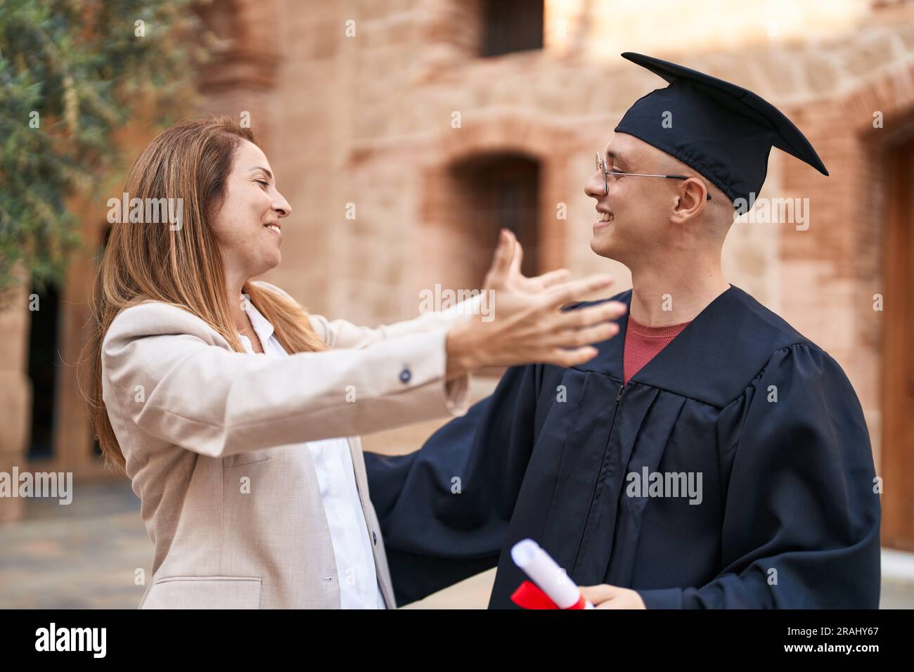 Man and woman mother and son hugging each other celebrating graduation ...