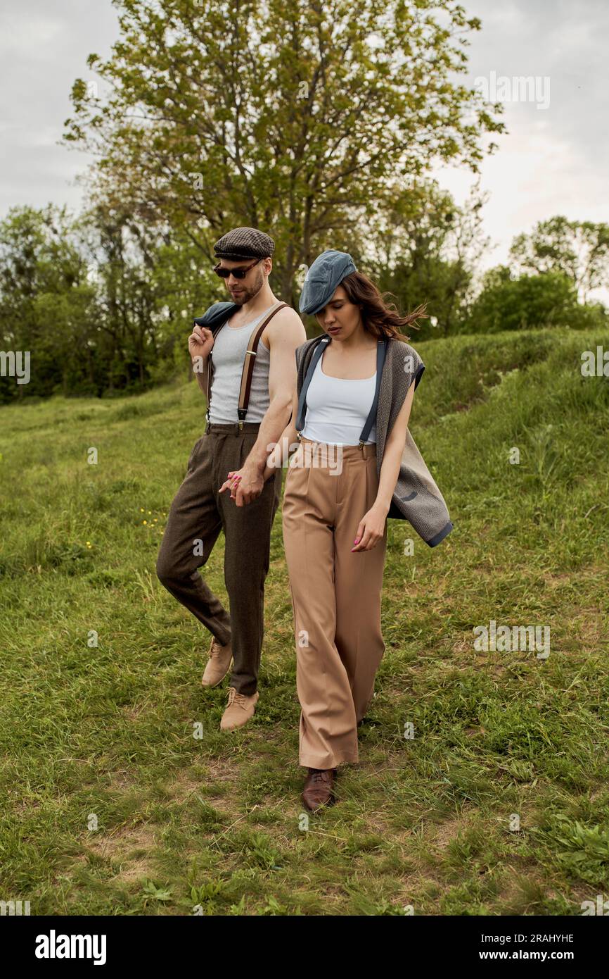 Full length of trendy romantic couple in rural outfits, newsboy caps ...