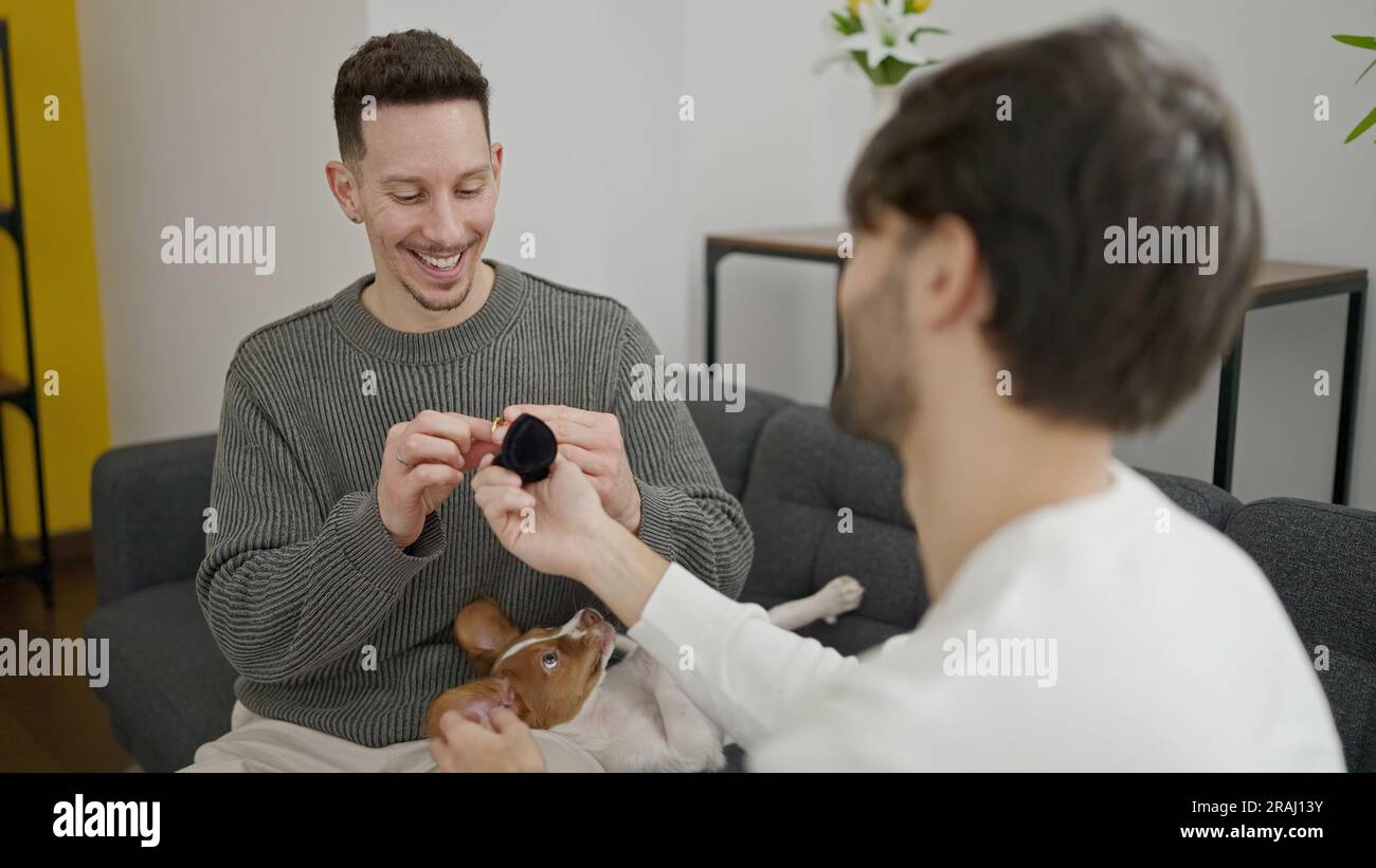 Two men couple smiling confident surprise with engagement proposal at ...