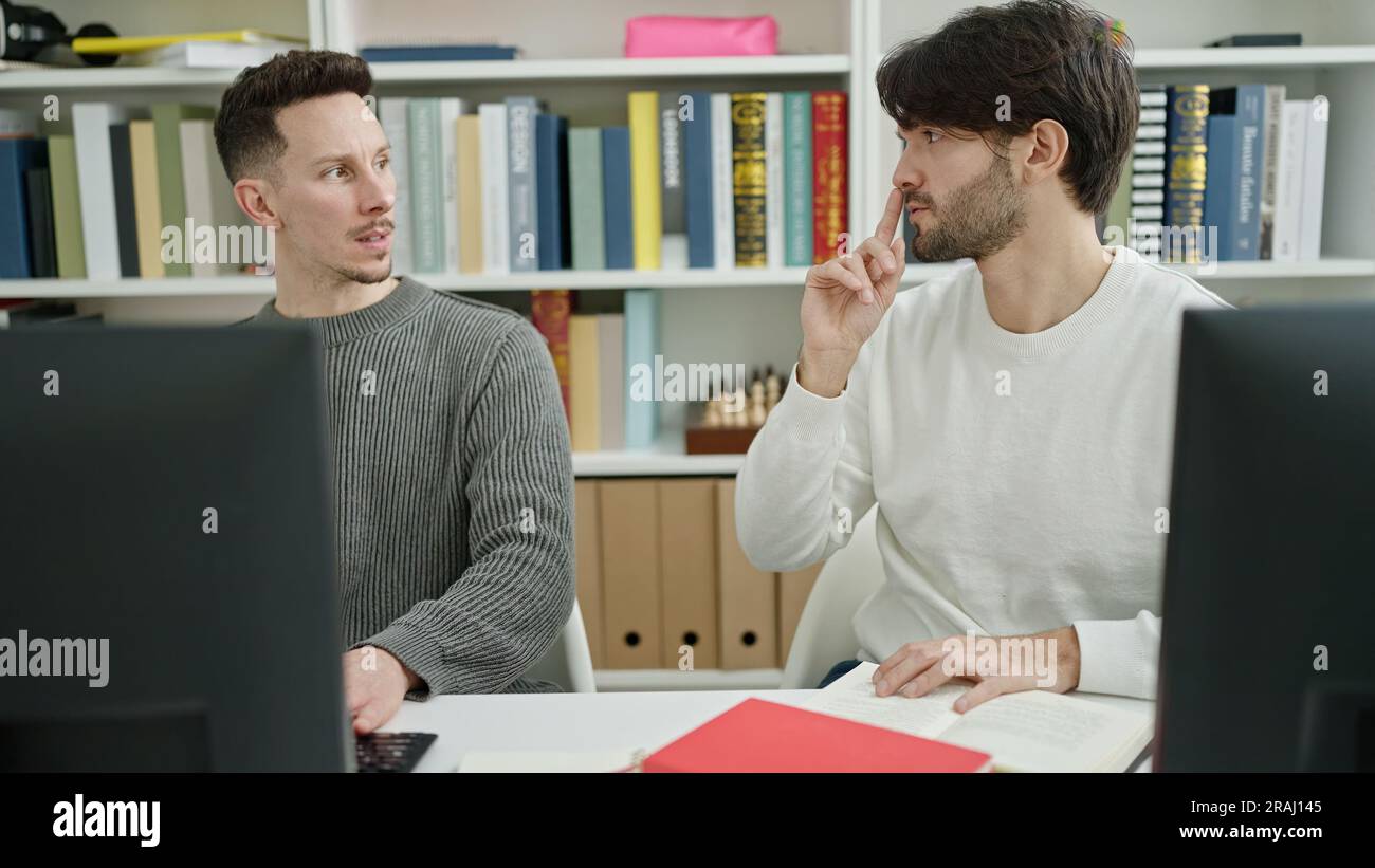 Two men students using computer studying at library university Stock Photo - Alamy