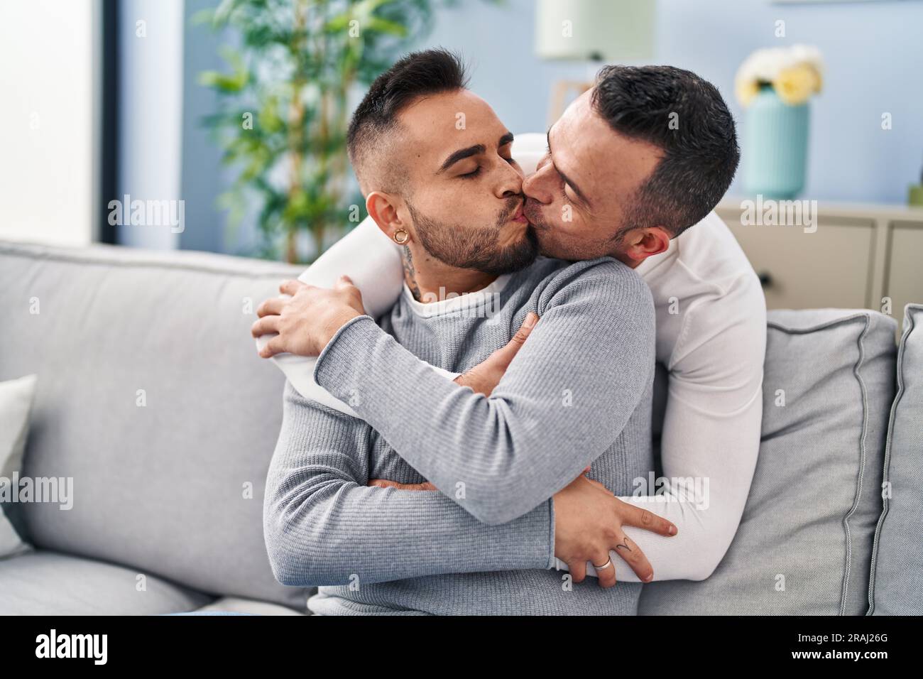 Two men couple hugging each other kissing at home Stock Photo - Alamy