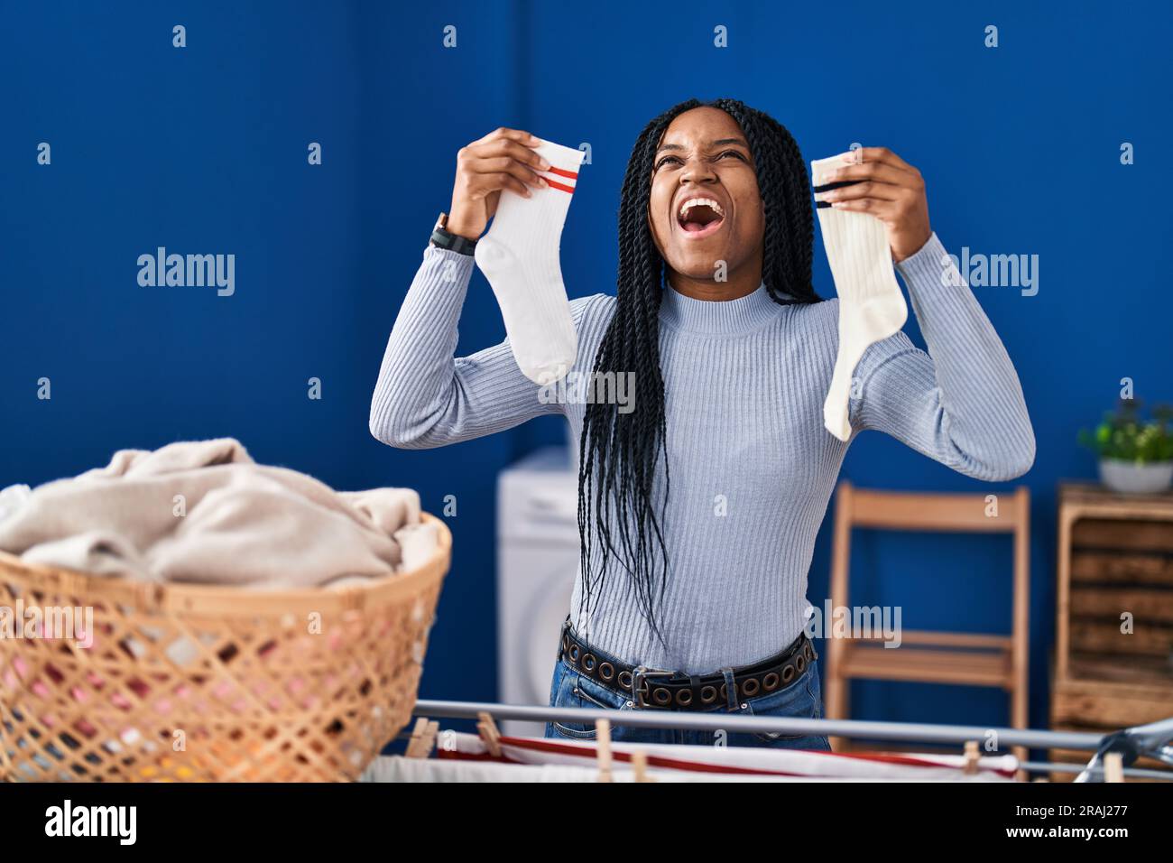 African american woman holding socks angry and mad screaming frustrated ...