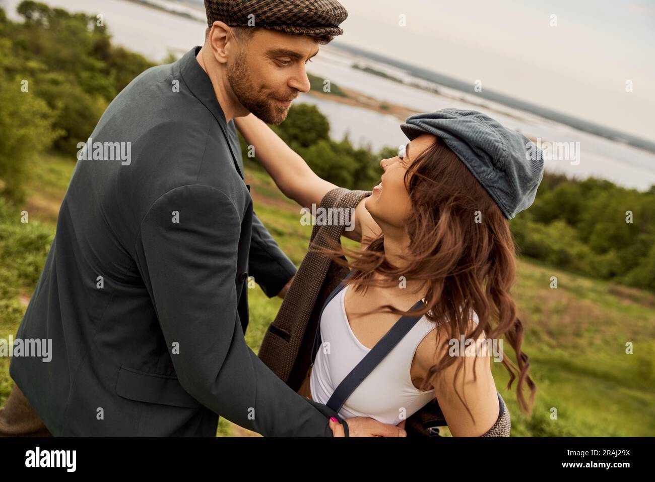 Cheerful and fashionable brunette woman in vintage suspenders and vest ...