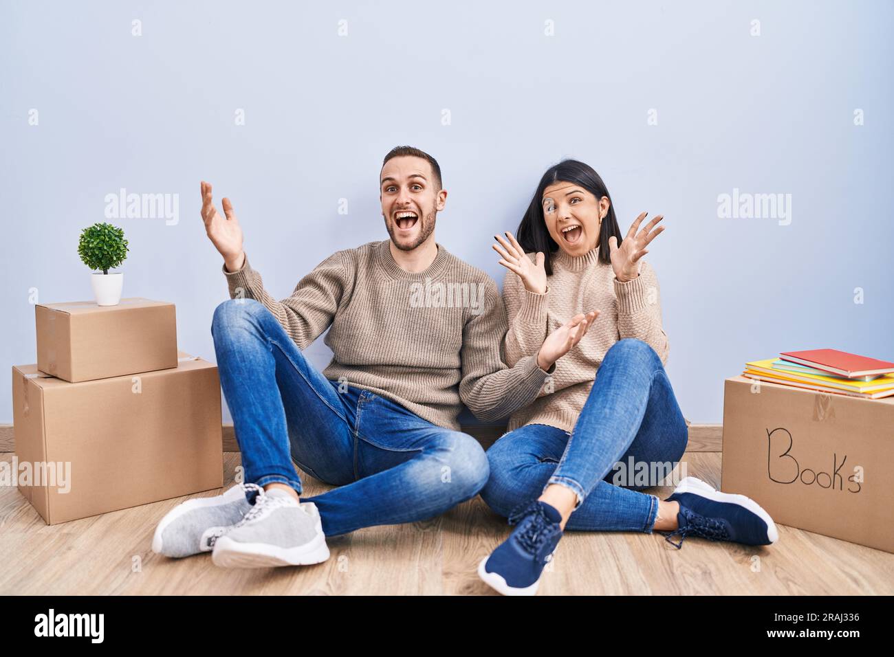 Young couple moving to a new home celebrating crazy and amazed for ...