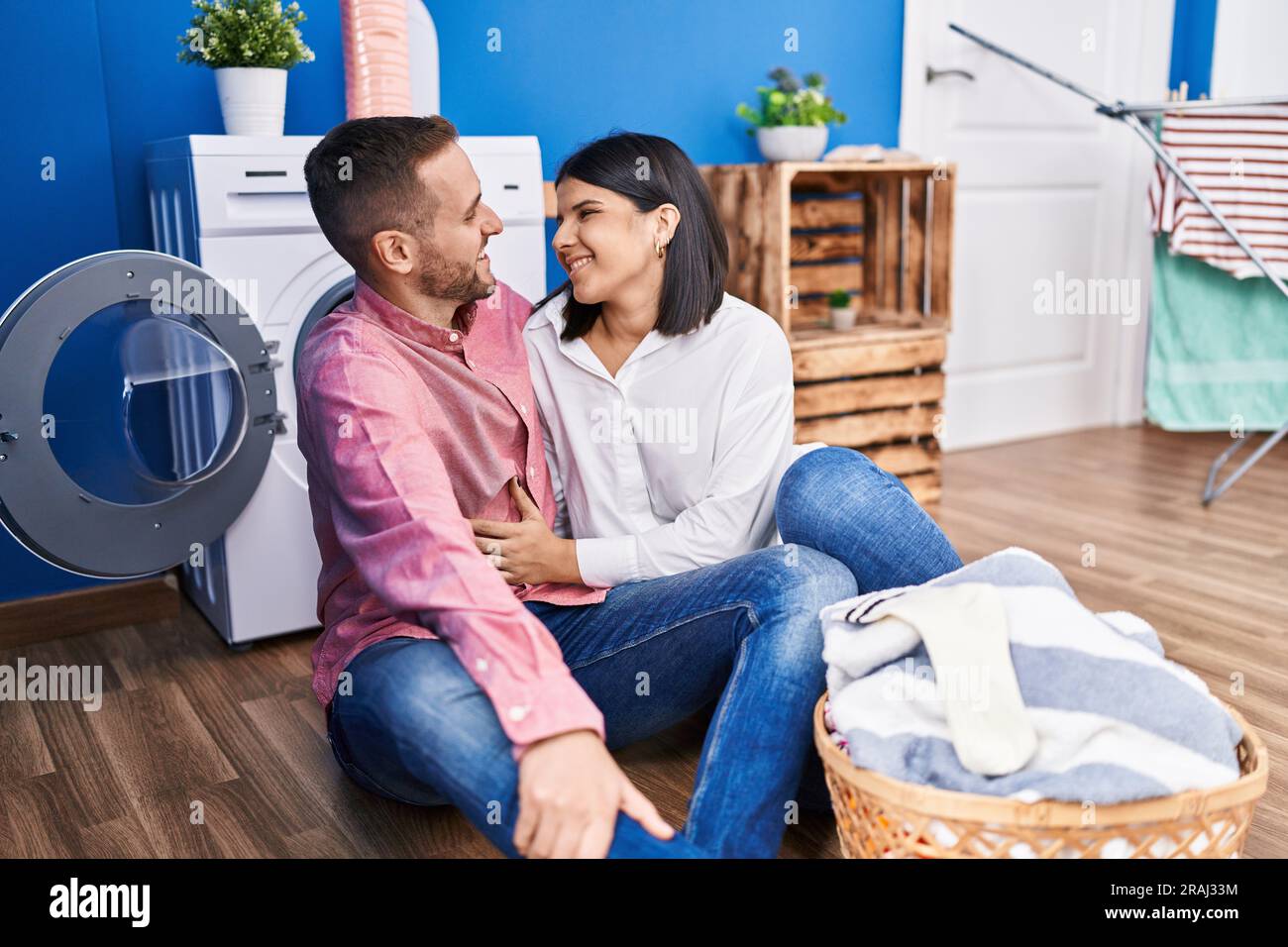 Man and woman couple washing clothes hugging each other at laundry room Stock Photo - Alamy