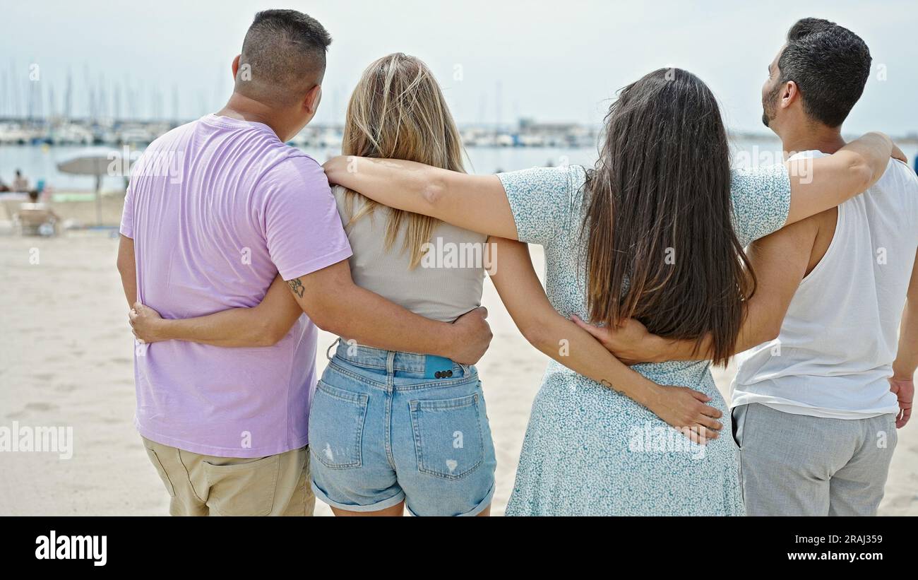 Group of people hugging each other backwards at beach Stock Photo - Alamy