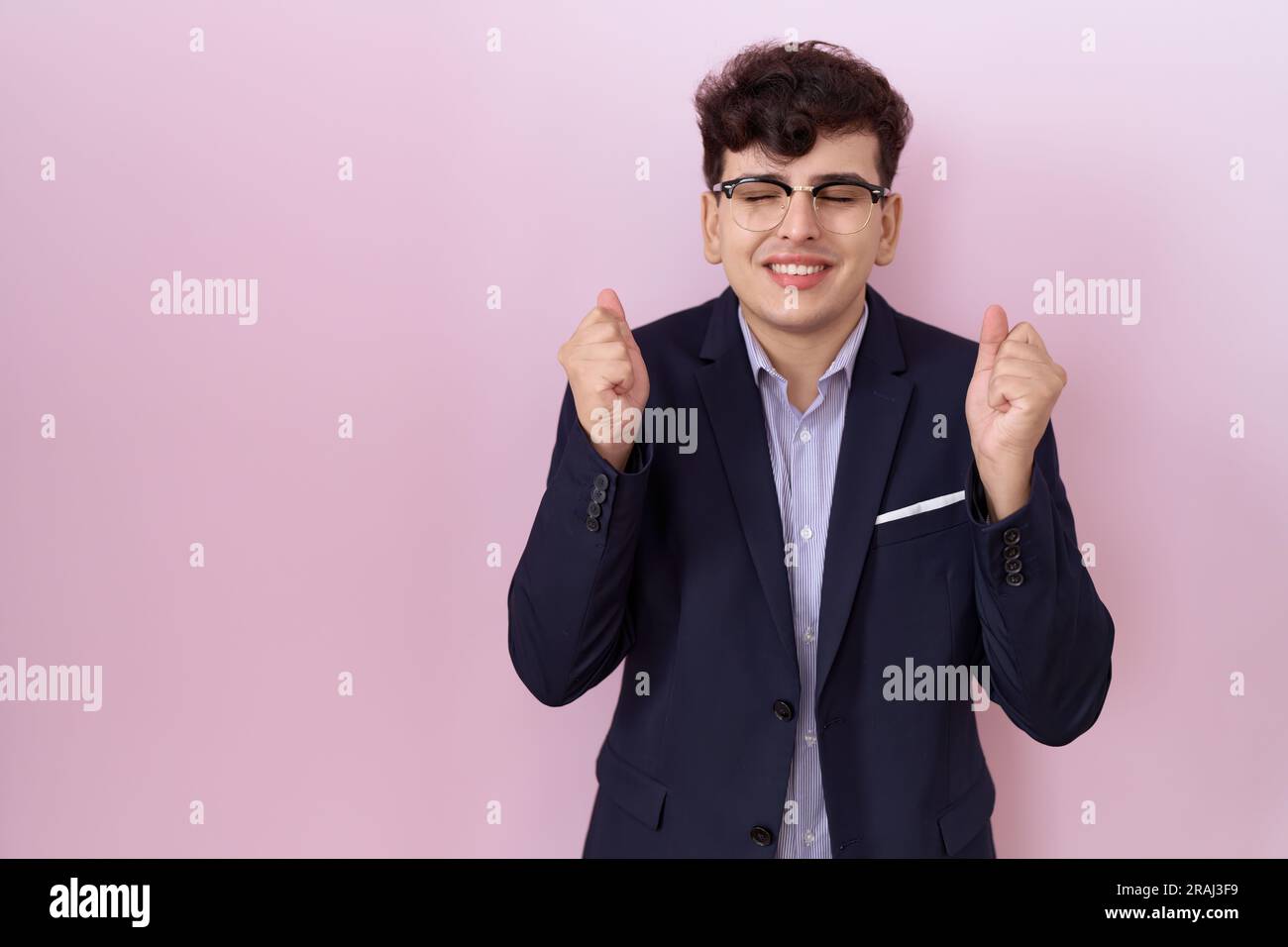 Young non binary man with beard wearing suit and tie excited for ...