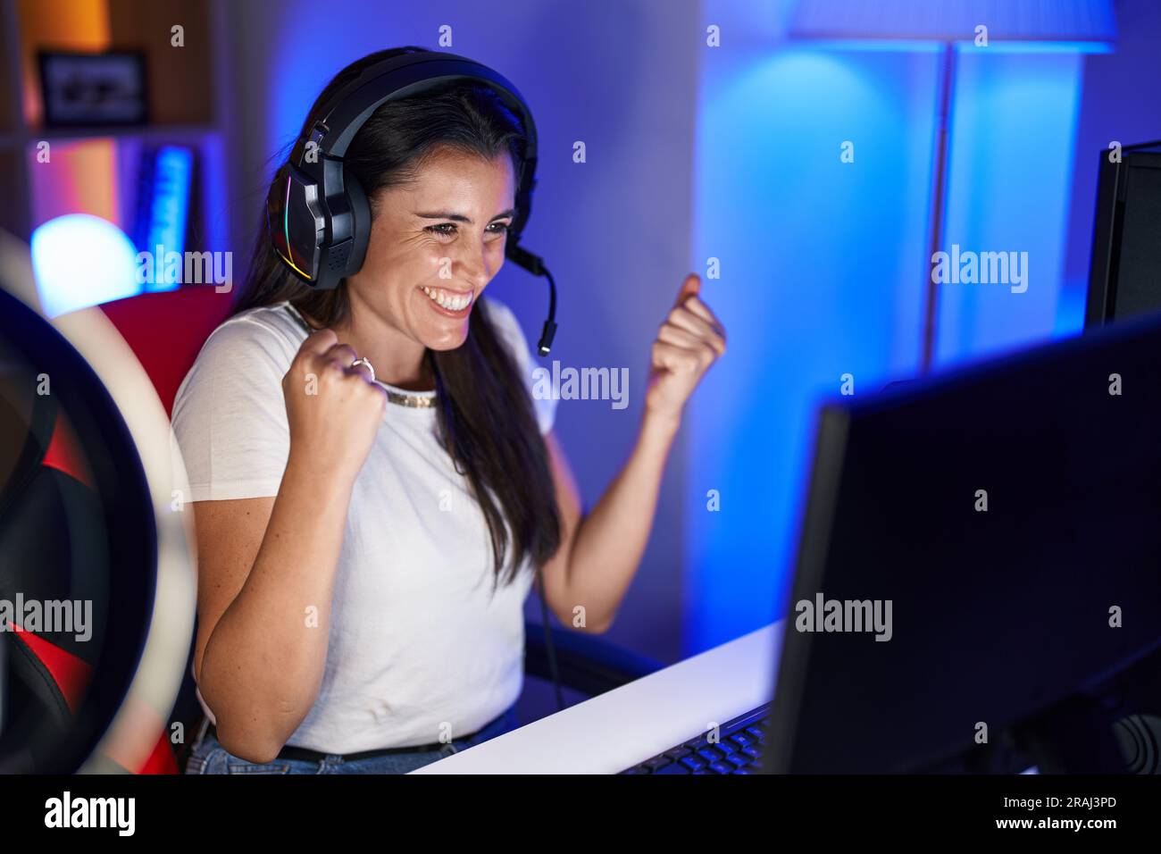 Young beautiful hispanic woman streamer playing video game with winner ...
