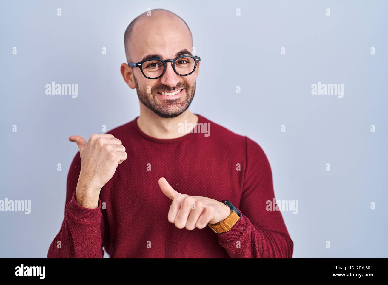 Young bald man with beard standing over white background wearing ...