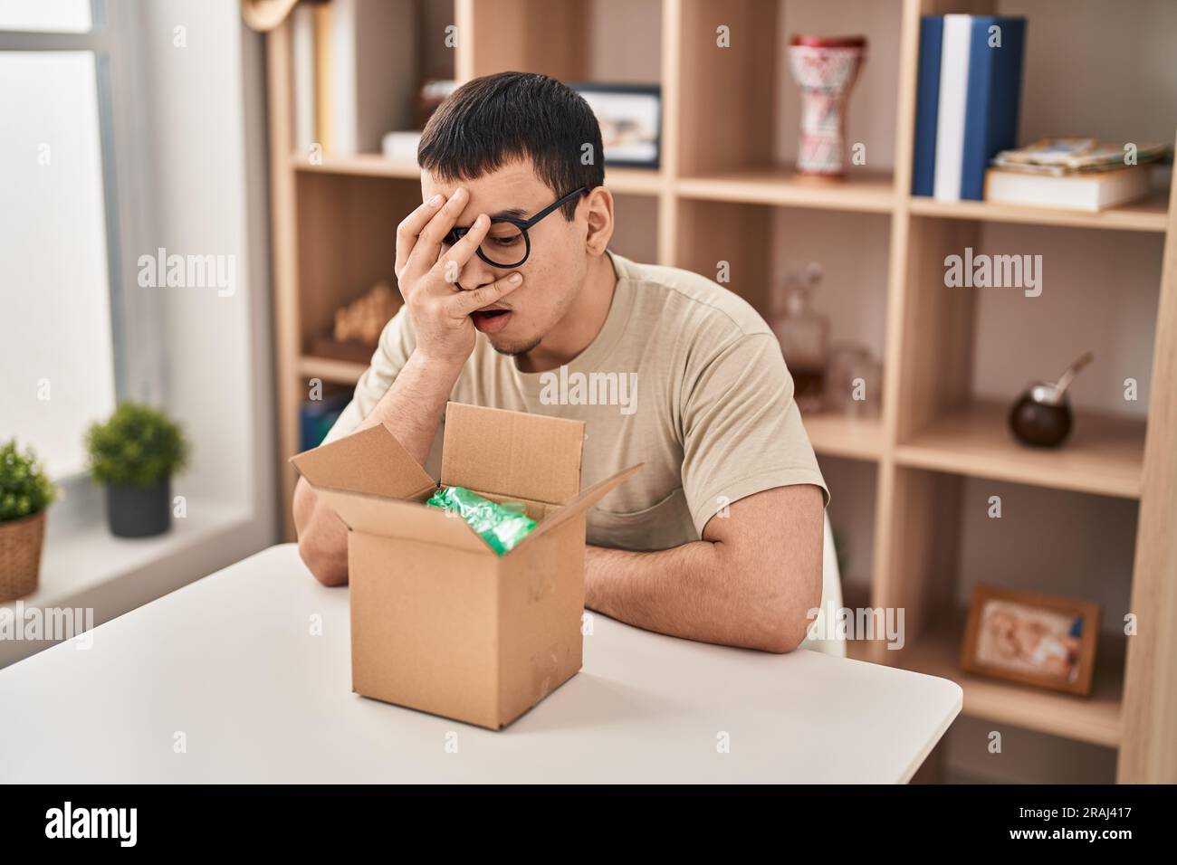 Young arab man with open gift in cardboard box peeking in shock ...