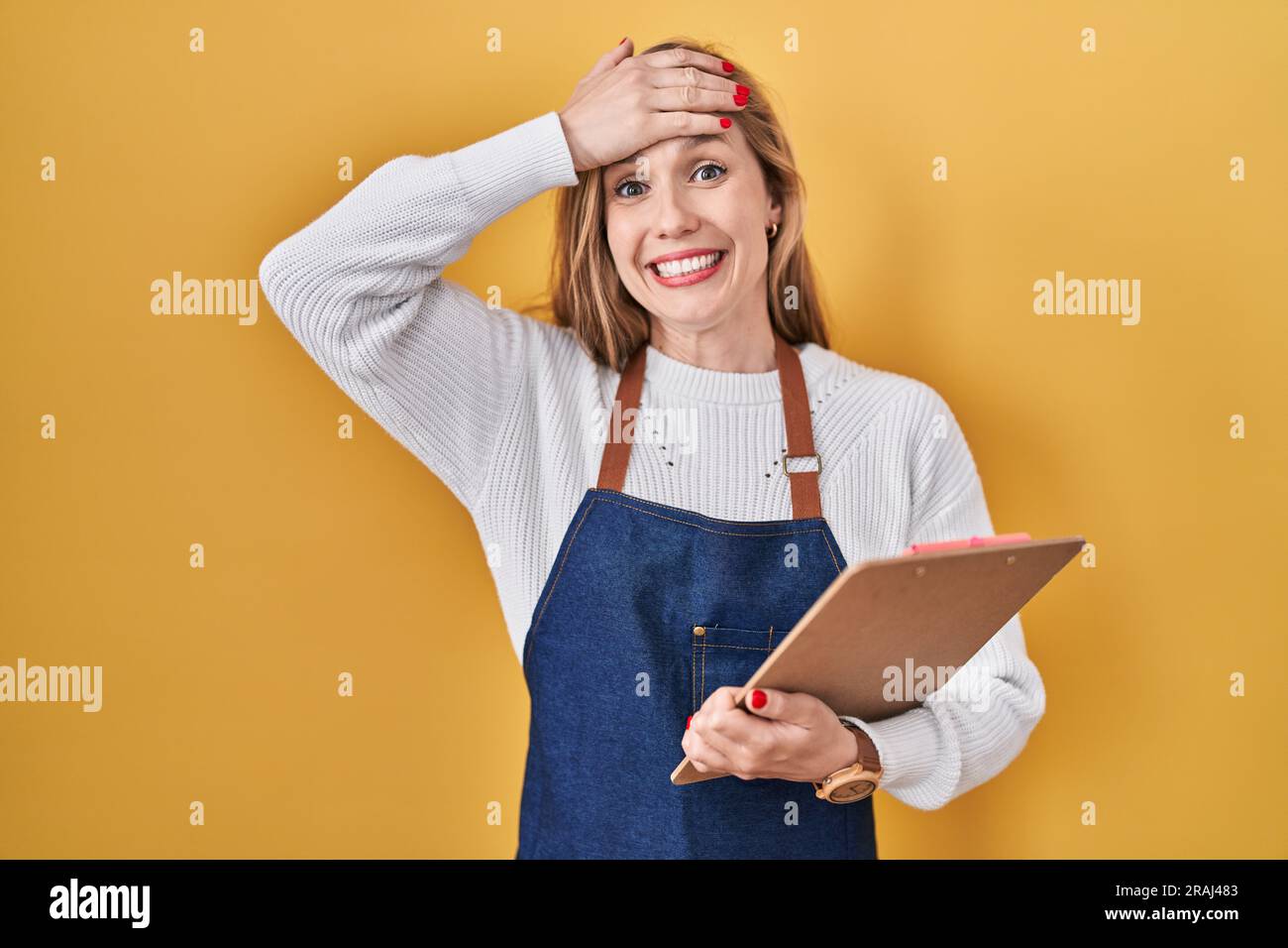 Young blonde woman wearing professional waitress apron holding ...