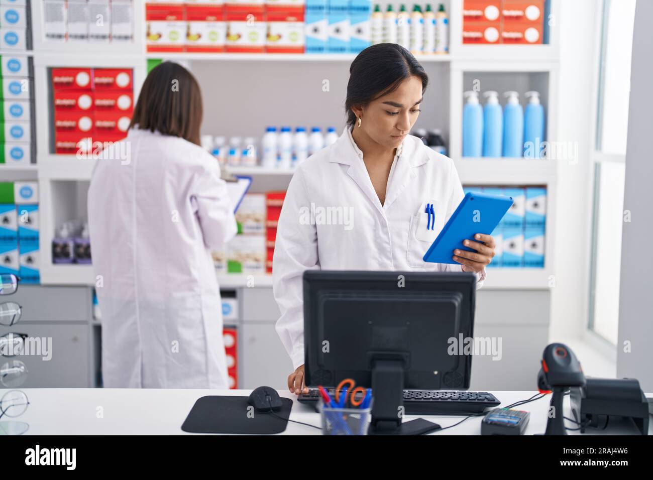 Two women pharmacist using touchpad working at pharmacy Stock Photo - Alamy