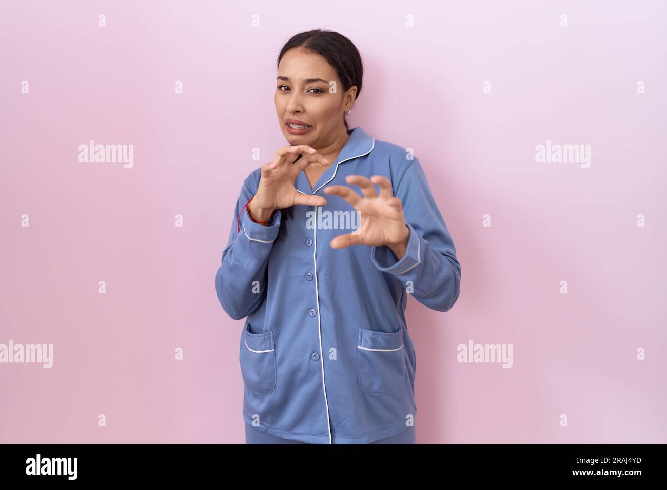 Young arab woman wearing blue pajama disgusted expression, displeased ...