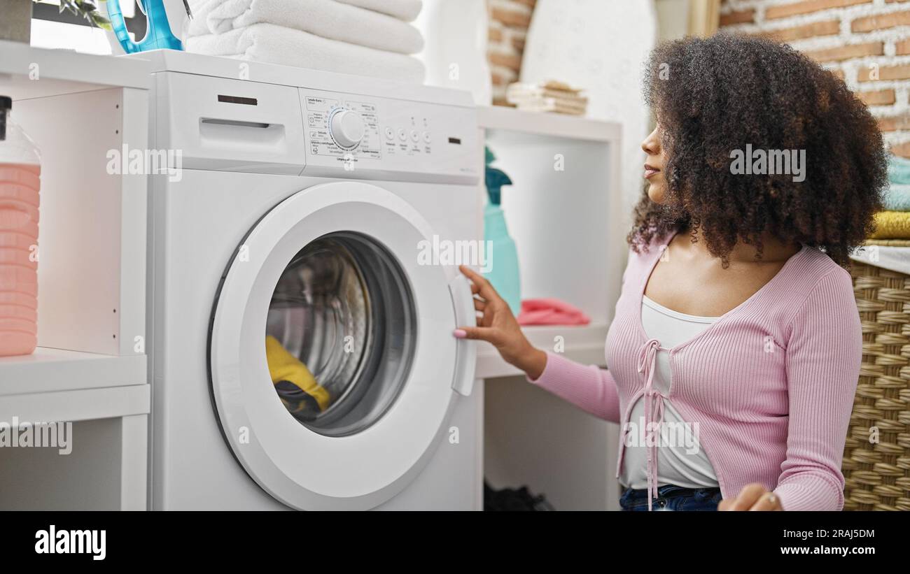 African american woman washing clothes at laundry room Stock Photo - Alamy
