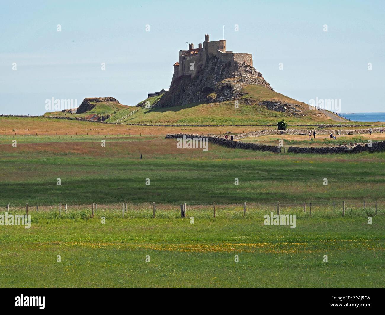classic sunny view of Lindisfarne Castle on highest part of whinstone ...