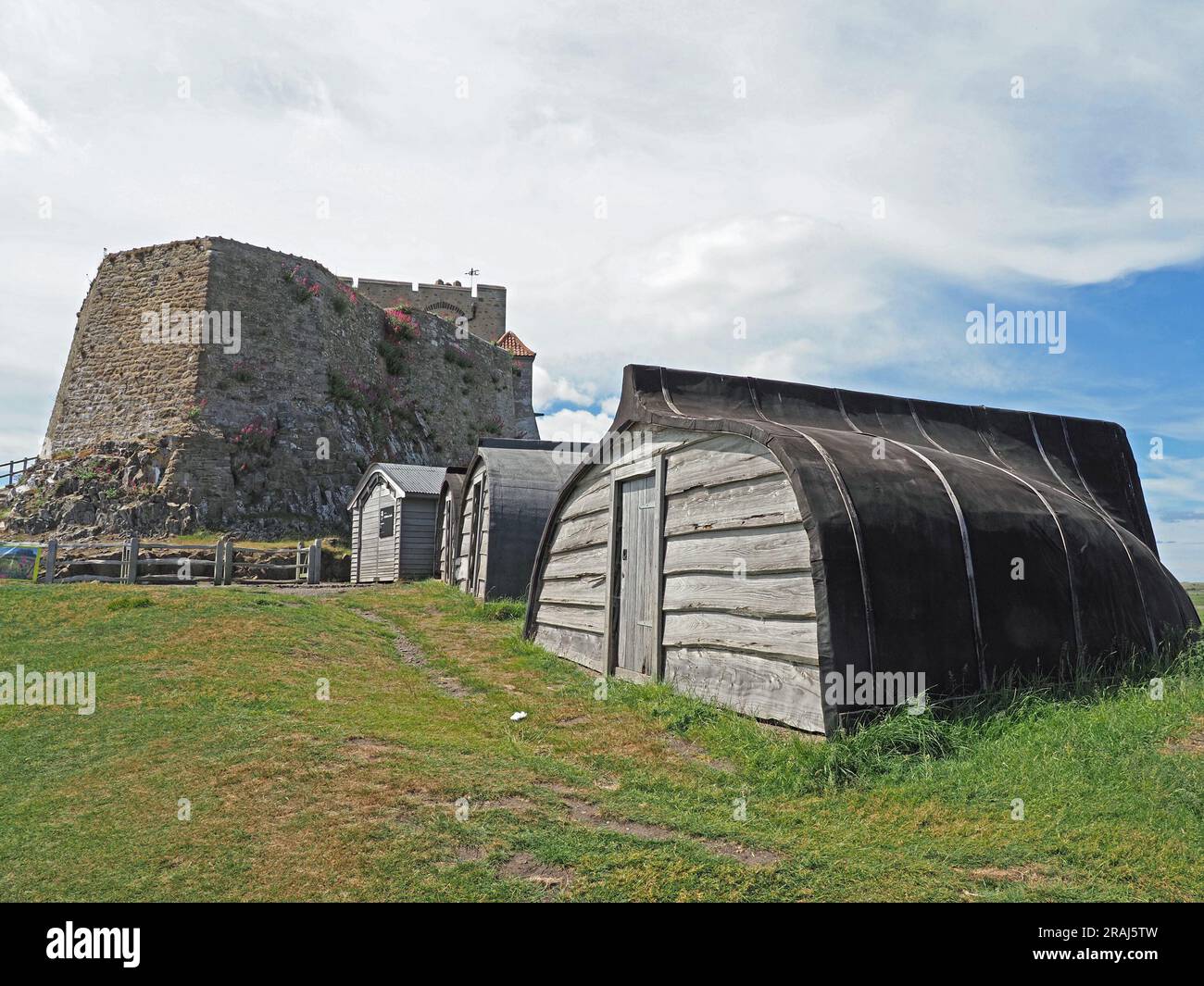 famous upturned wooden boat sheds beneath historic stone built ...