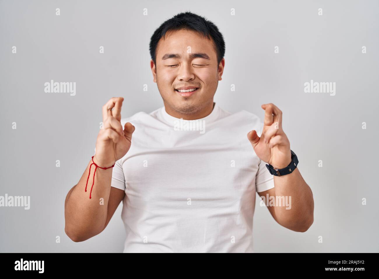 Young chinese man standing over white background gesturing finger ...