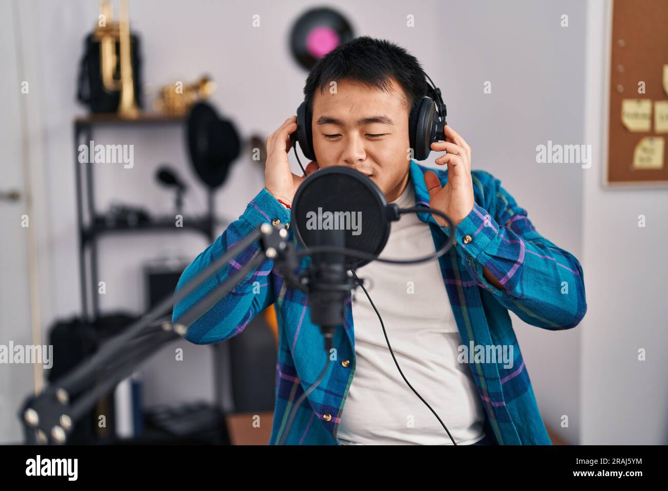 Young chinese man singer singing song at music studio Stock Photo - Alamy