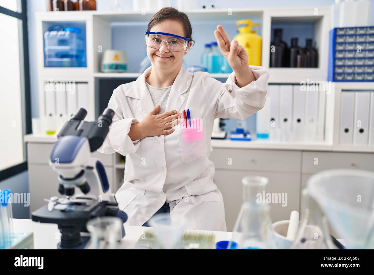 Hispanic girl with down syndrome working at scientist laboratory ...
