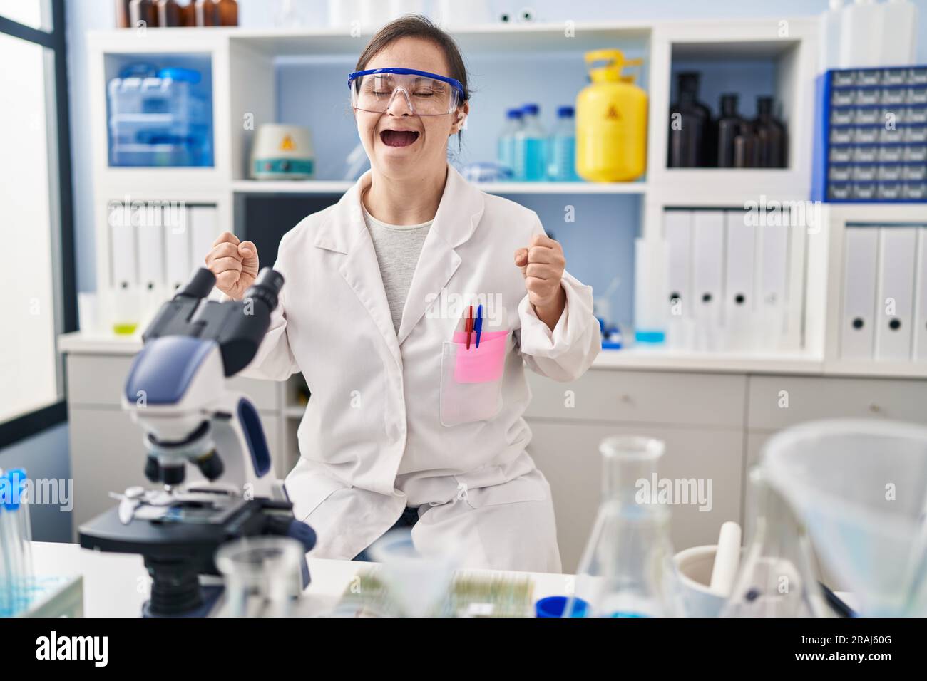 Hispanic girl with down syndrome working at scientist laboratory ...