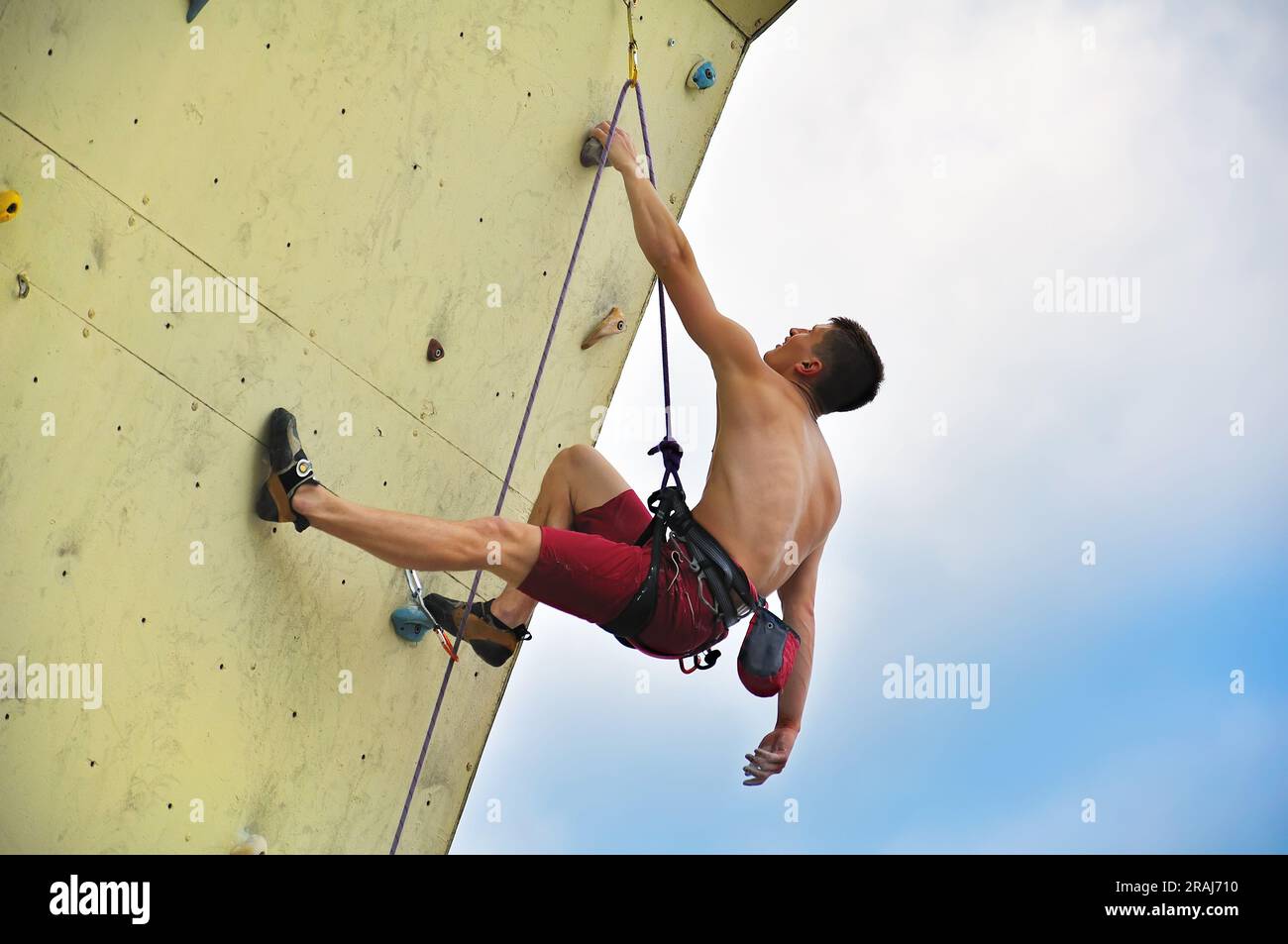 Muscular climber climbing on wall Stock Photo - Alamy