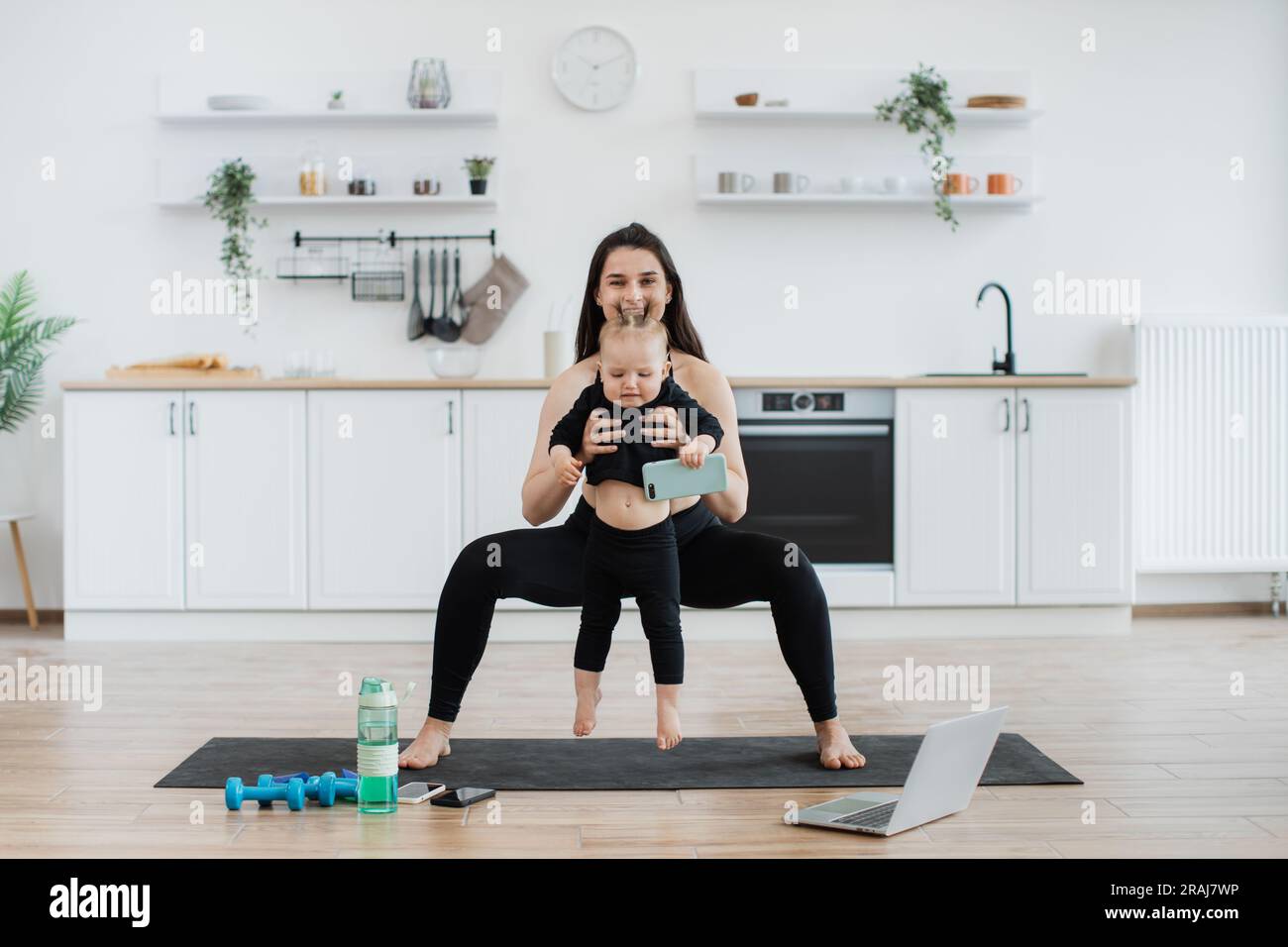 Attractive caucasian adult in athletic wear practising wide squats with ...