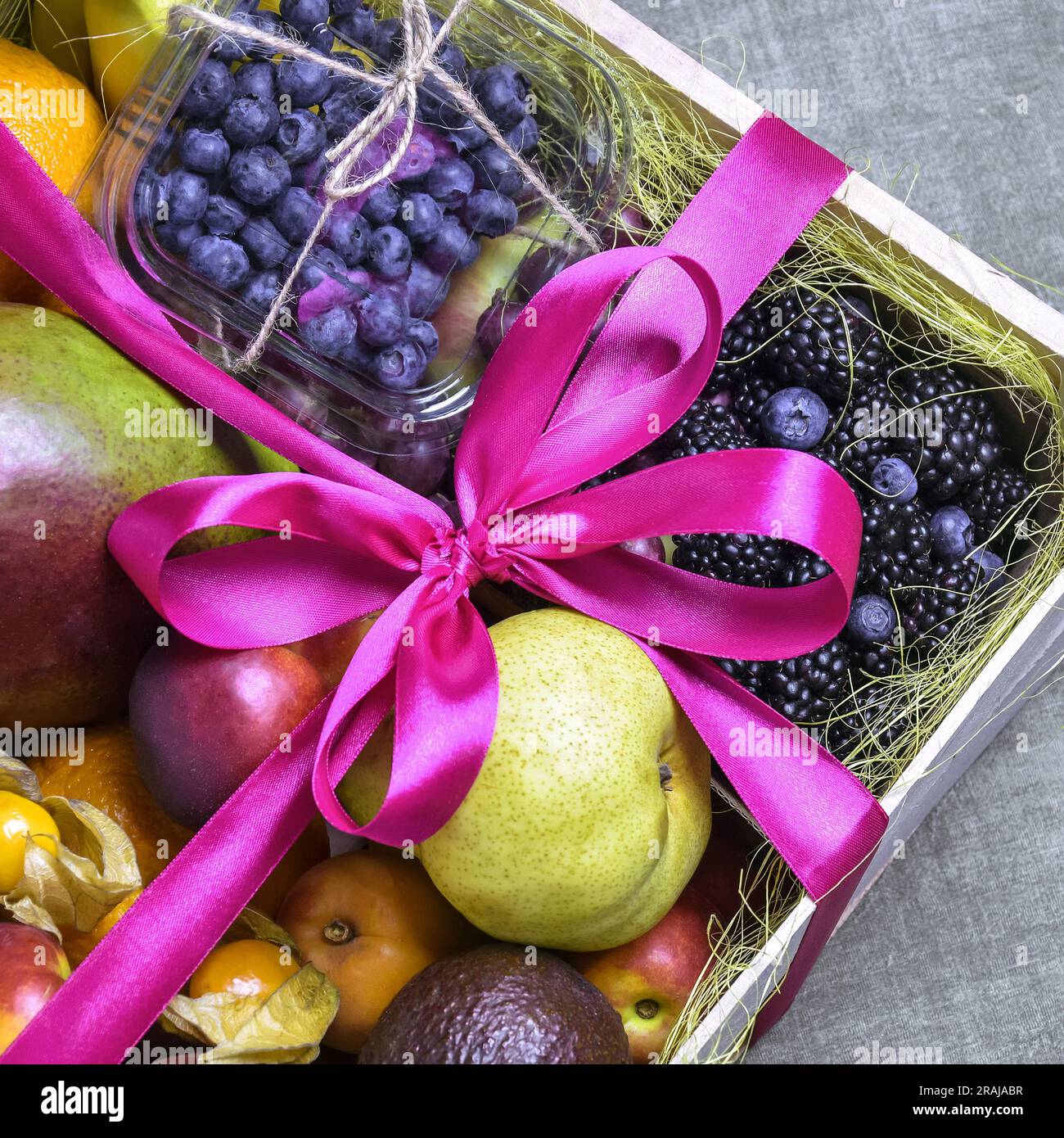 Juicy ripe fruits and berries are beautifully stacked in wooden box ...