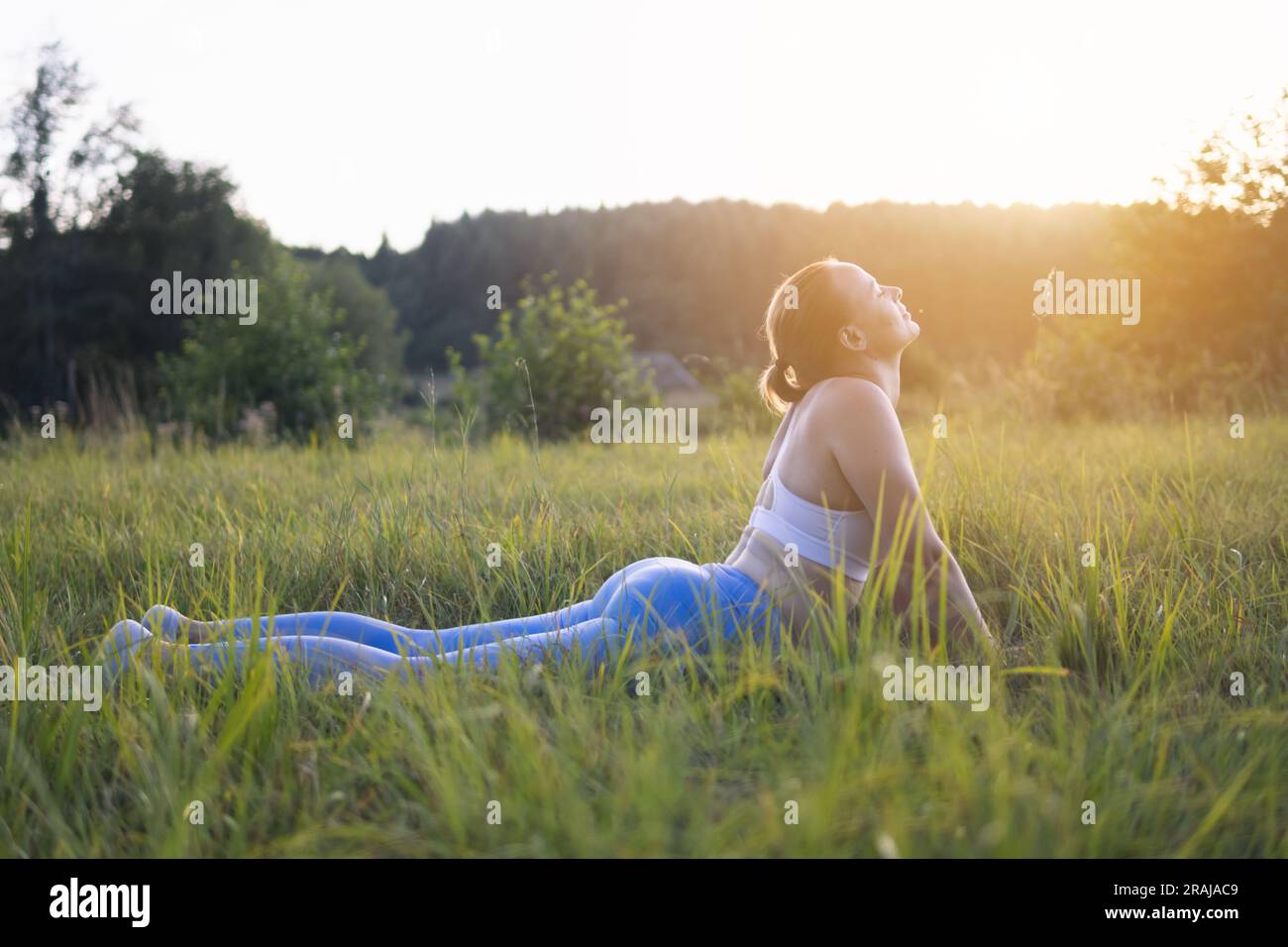girl of light, athletic appearance, in blue leggings and a white topic ...