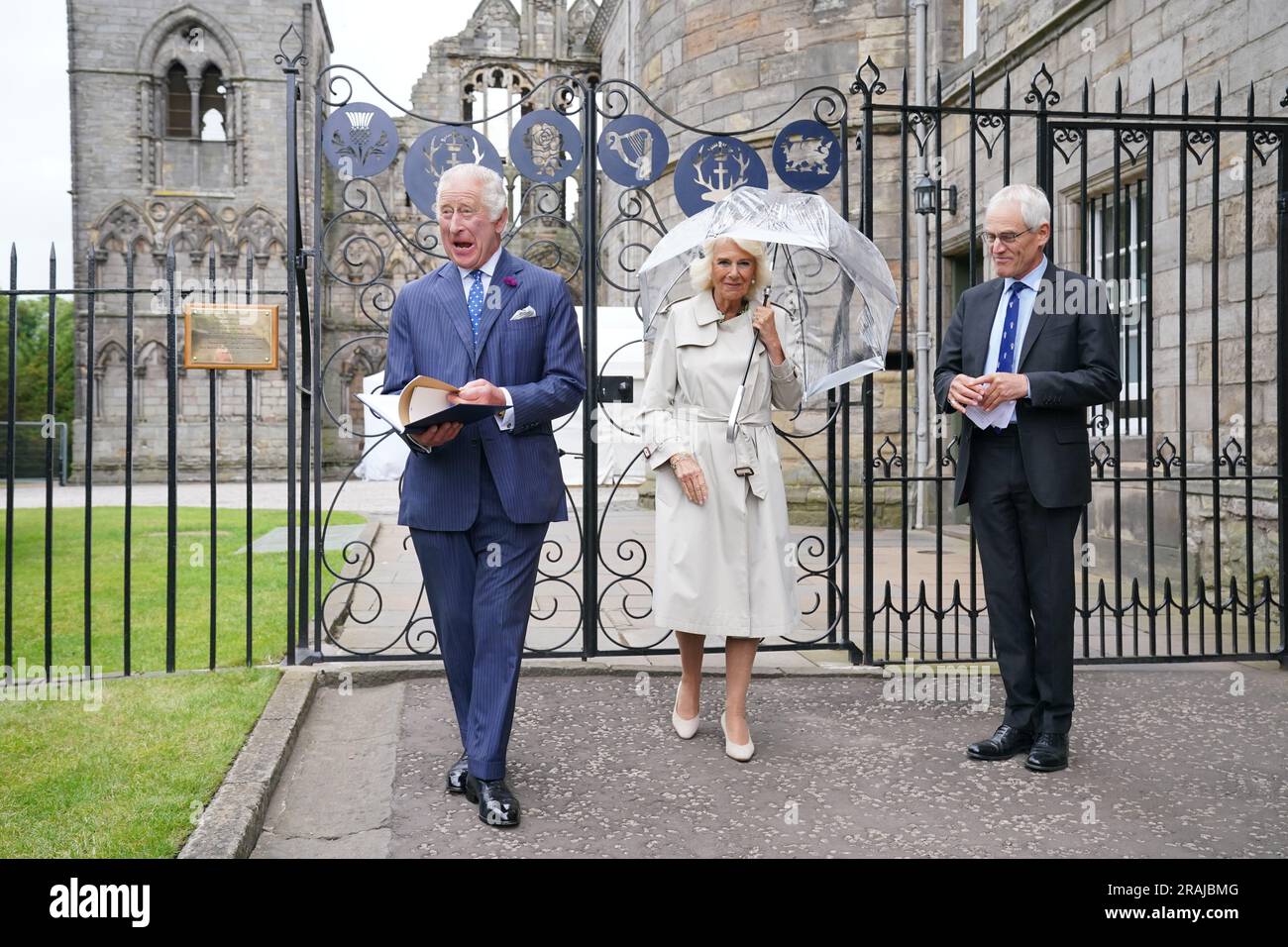 King Charles III and Queen Camilla are presented with a leather-bound ...