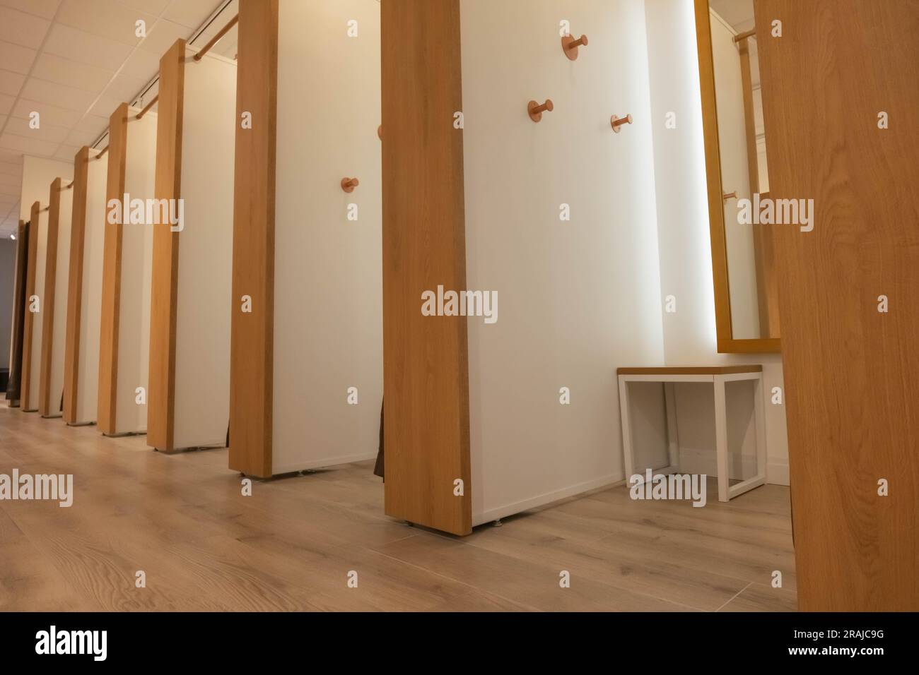 empty fitting rooms in brown and white in a store of things. there is a ...