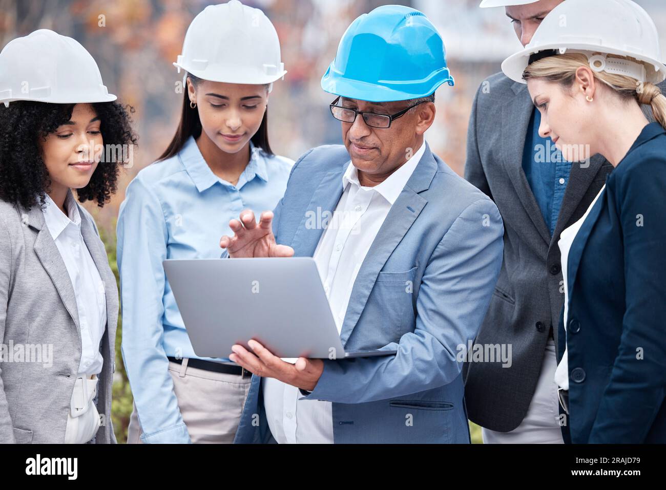 Teamwork, engineer and leader of people with laptop outdoor in city ...