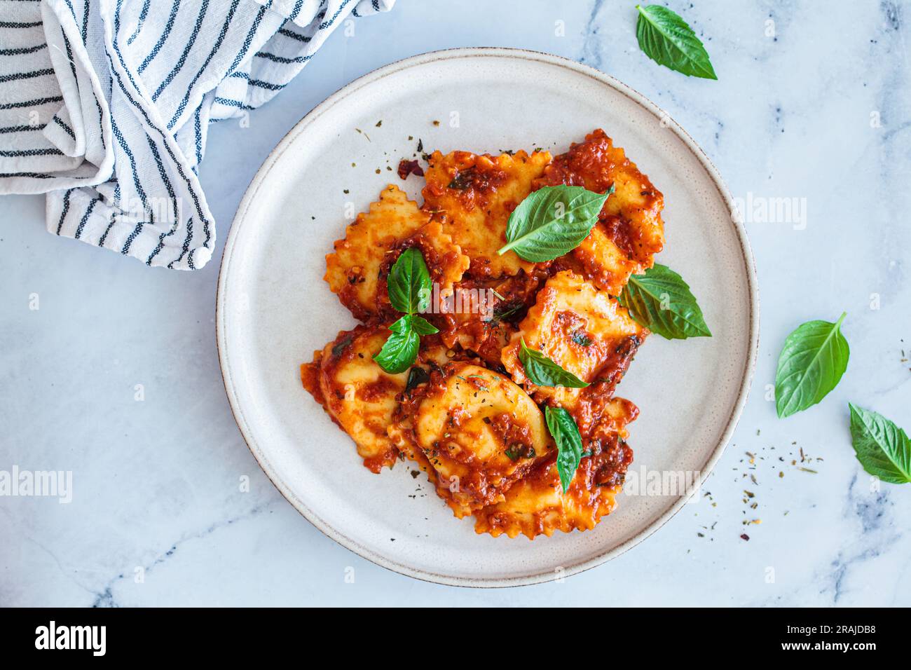 Ravioli with ricotta, tomato sauce and basil, white marble background ...