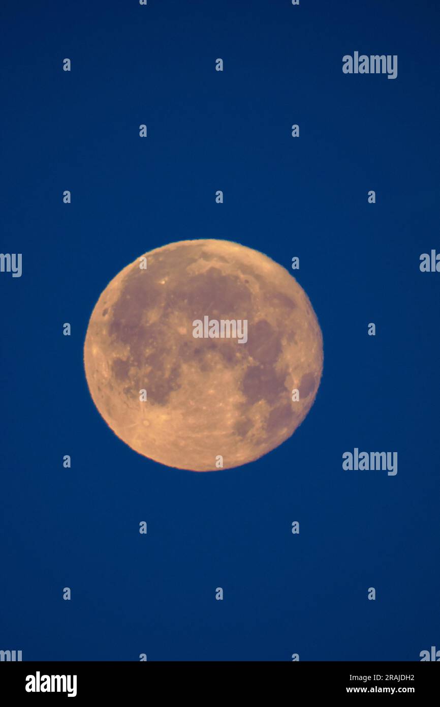 Orange colored moon through telescope at sunrise Stock Photo - Alamy