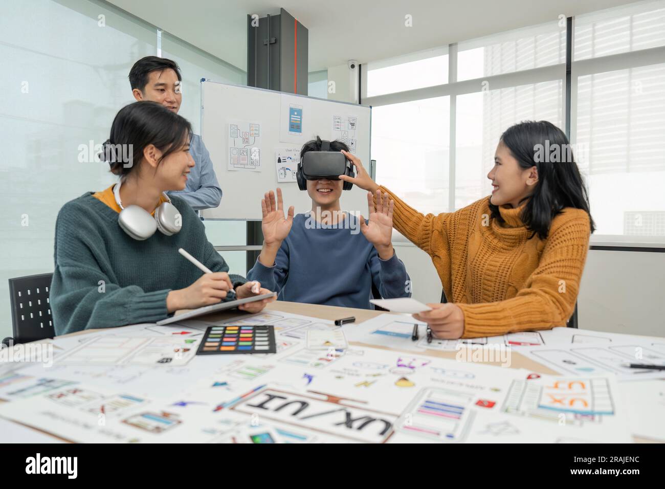 Diverse development team testing virtual reality headset, brainstorming ...