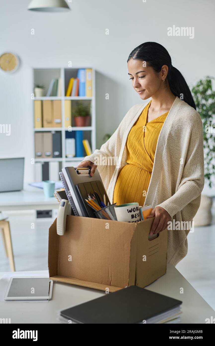 Pregnant businesswoman going on maternity leave, she standing at her ...