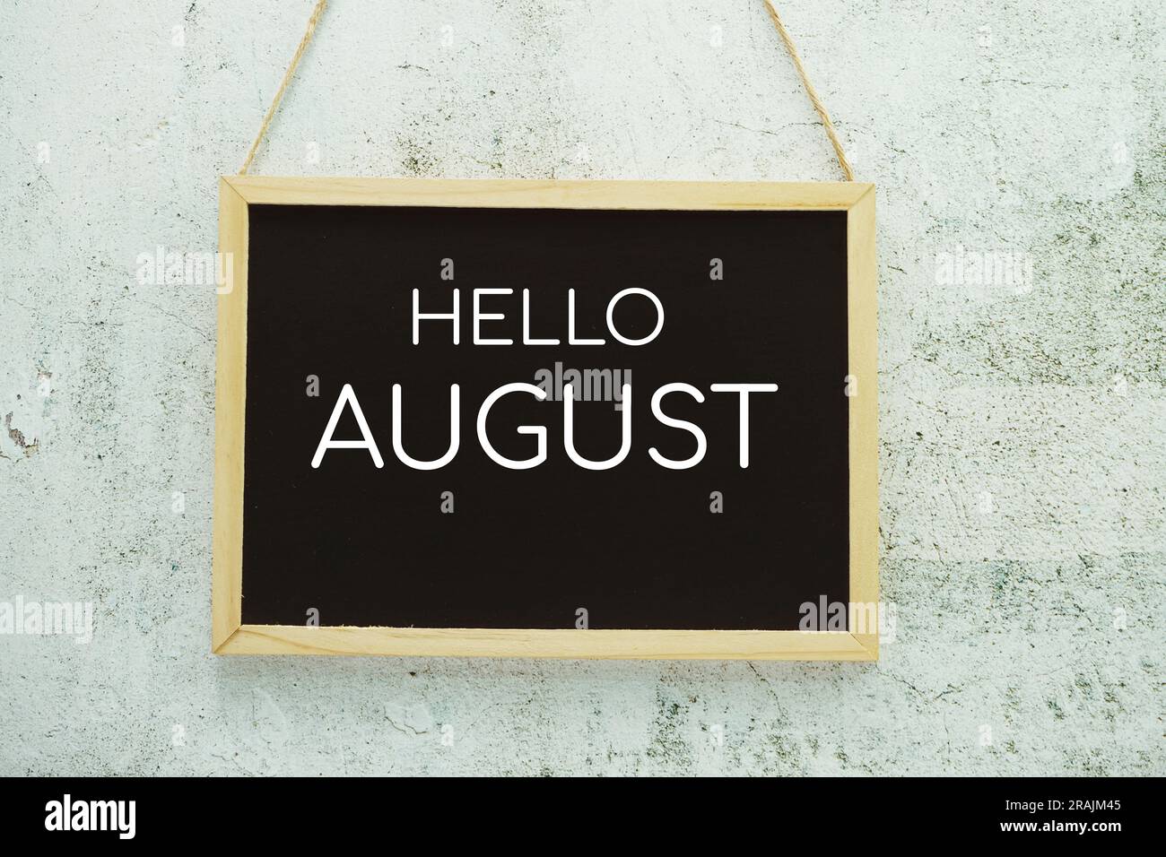 Hello August typography text on blackboard hanging against on the ...