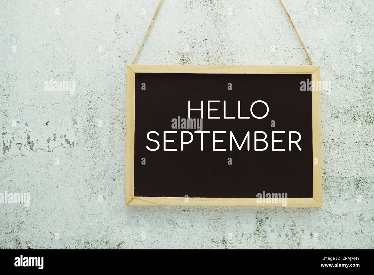 Hello September typography text on blackboard hanging against on the ...