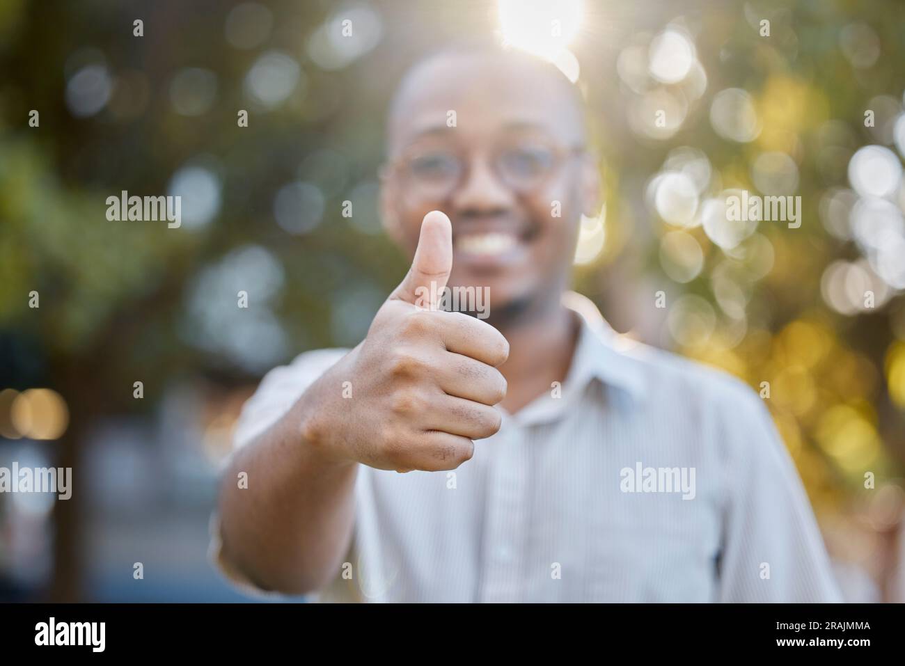 Black man, hands and thumbs up in park for success, good job or ...