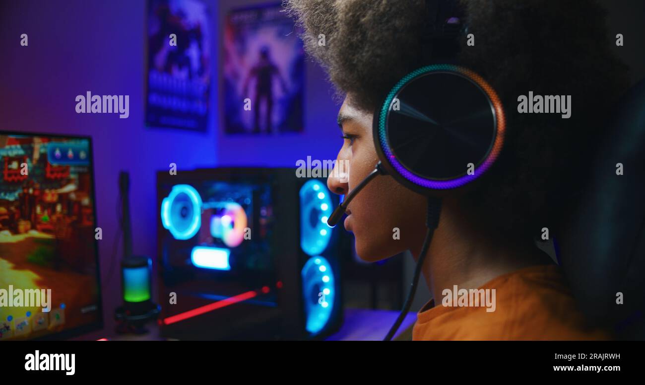 Happy gamer in headphones wins a round in multiplayer game on home ...