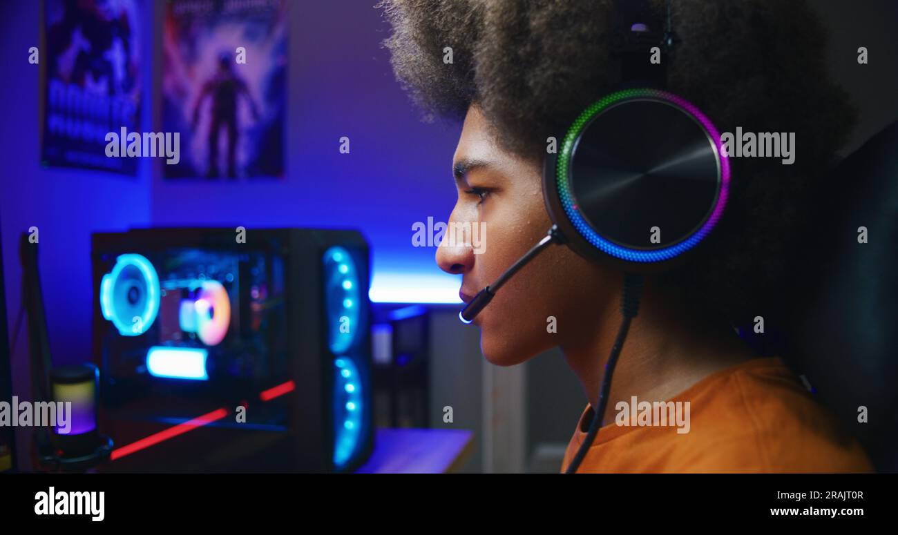 Happy gamer in headphones wins a round in multiplayer game on home ...