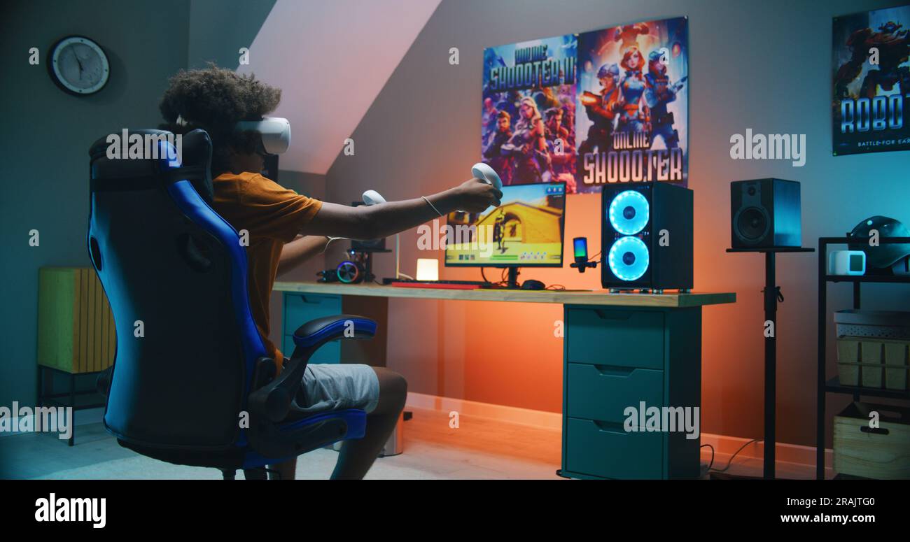 African American teenager in VR headset plays virtual third-person 3D ...