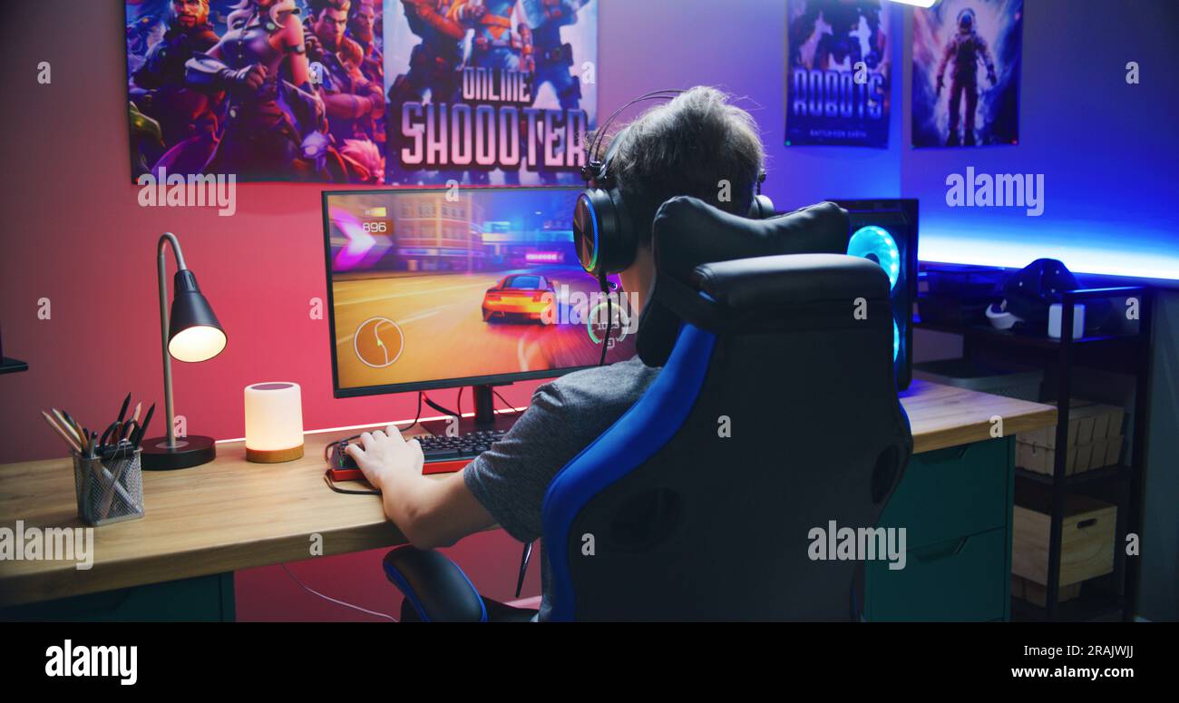 Young gamer plays in car racing simulator on PC at home. Computer ...