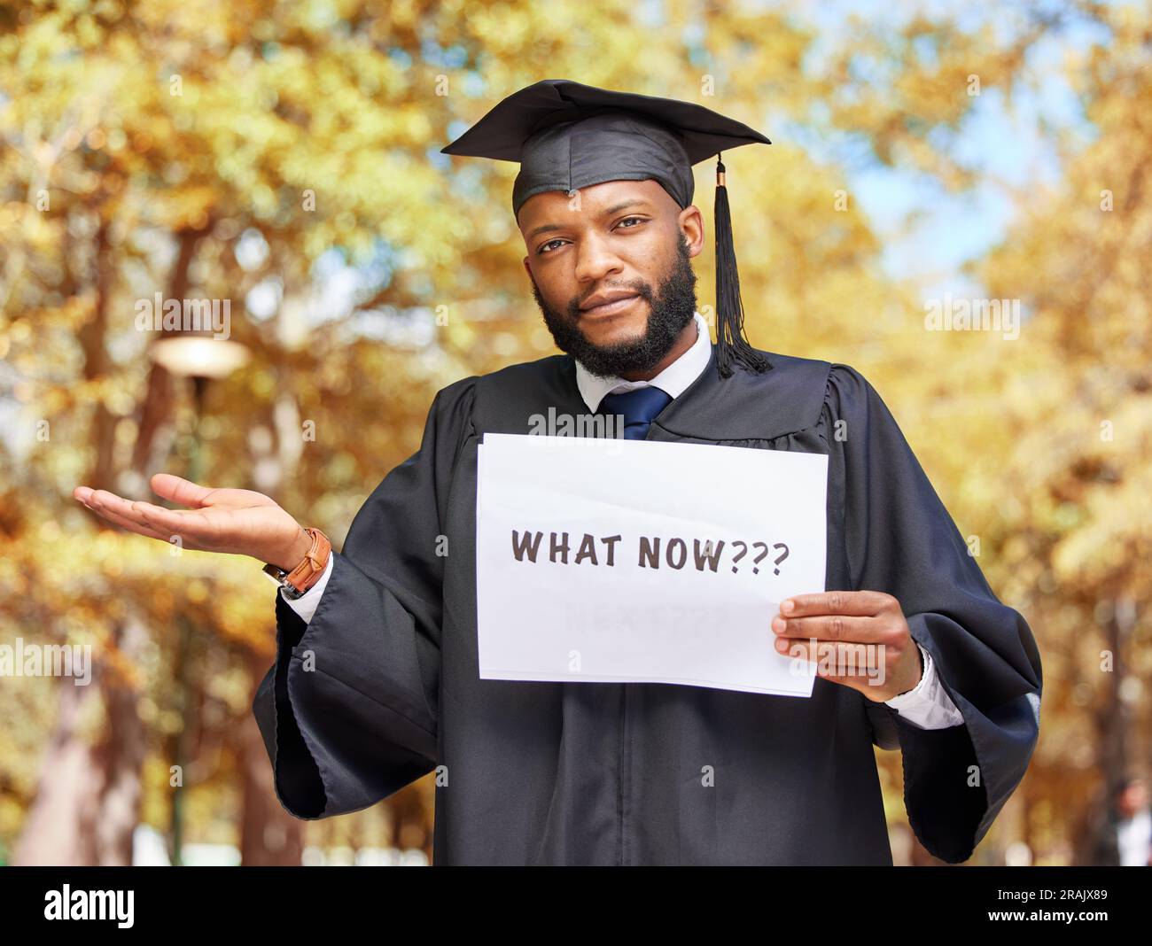 Paper sign, graduation and portrait of a man in a garden by his college ...