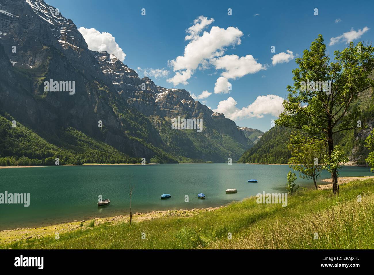 Boats on the shore of Lake Kloentalersee, an idyllic mountain lake in ...